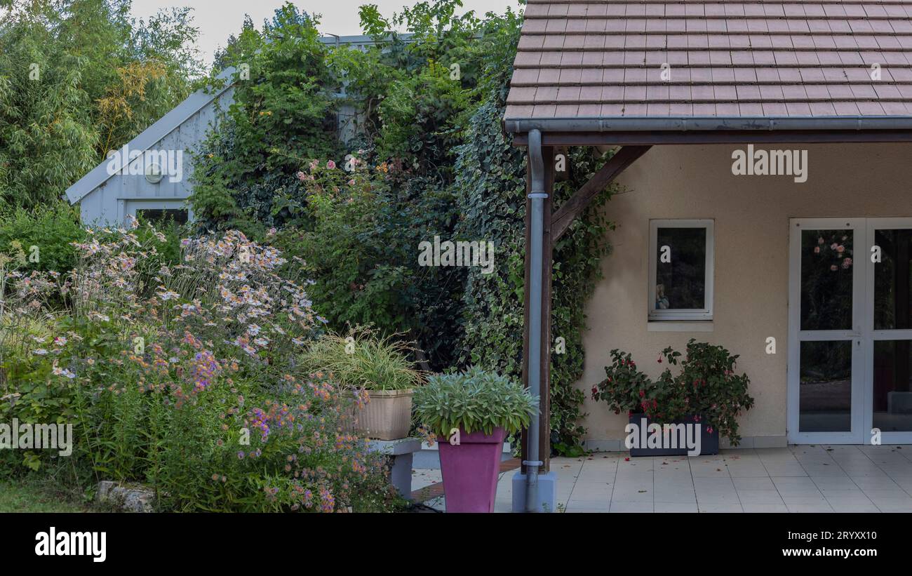 Building with verander and flower garden with pink planters Stock Photo ...