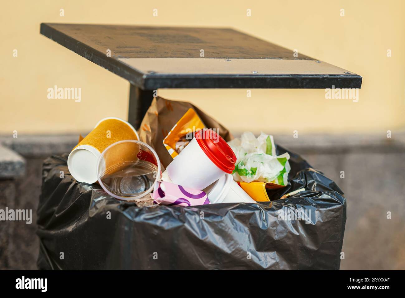 Garbage in a city street trash can closeup, plastic and paper takeaway ...