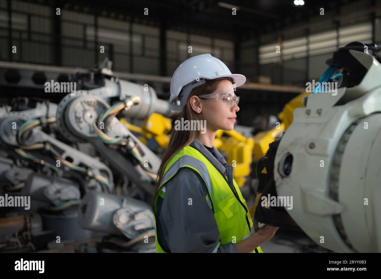 In the robots warehouse, Female engineer happily with updating software ...