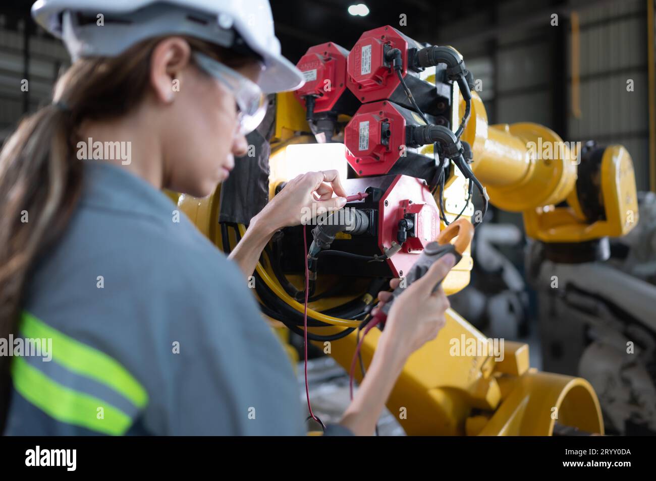 In the robots warehouse, A female engineer inspects the electrical ...