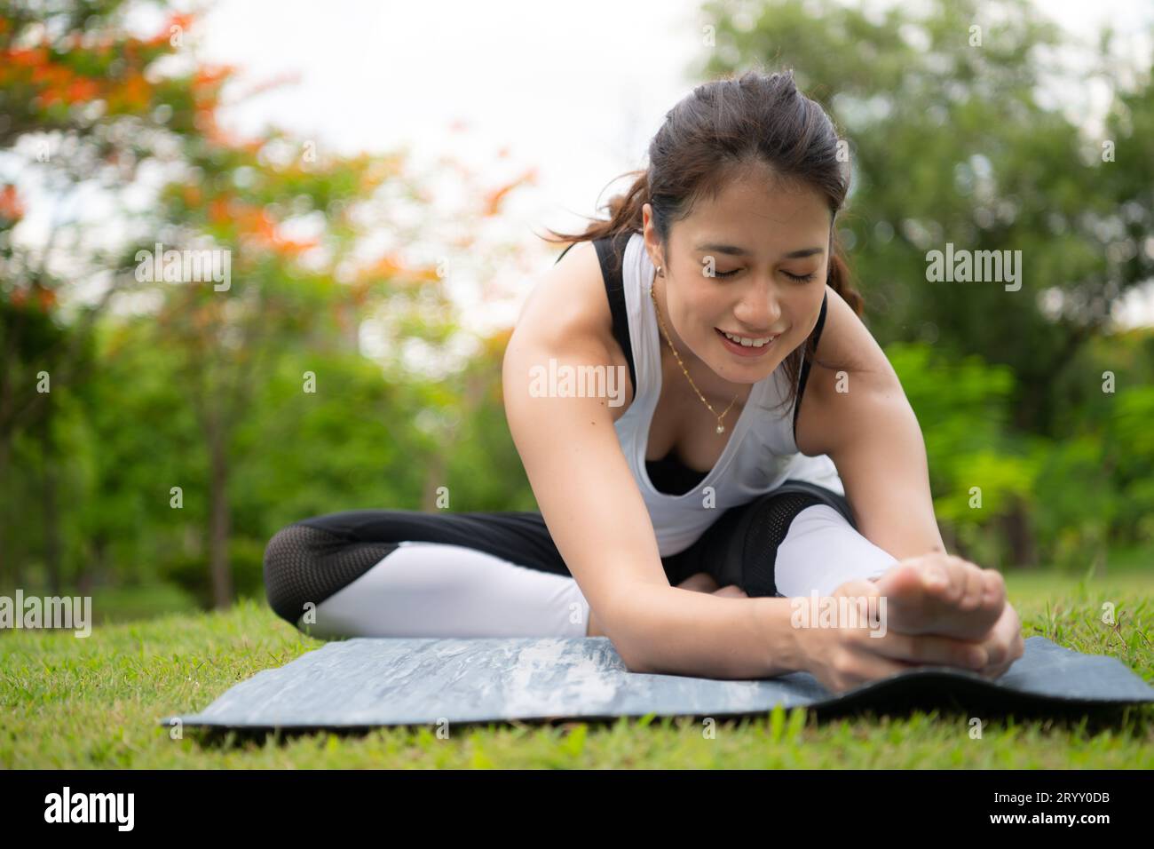 Young female with outdoor activities in the city park, Yoga is her ...
