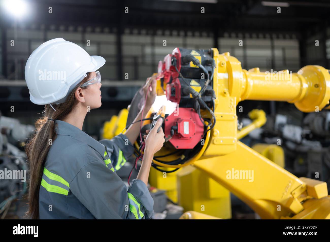 In the robots warehouse, A female engineer inspects the electrical ...