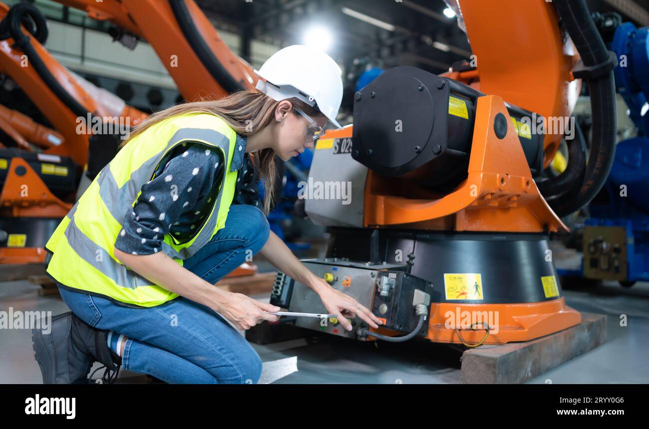 Female Technician Inspecting and repairing robotics arm in robots ...