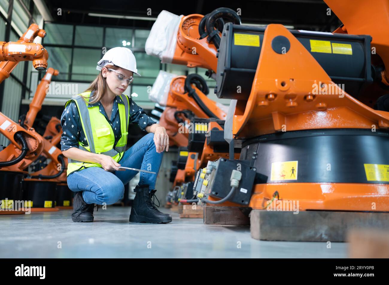 Female Technician Inspecting and repairing robotics arm in robots ...