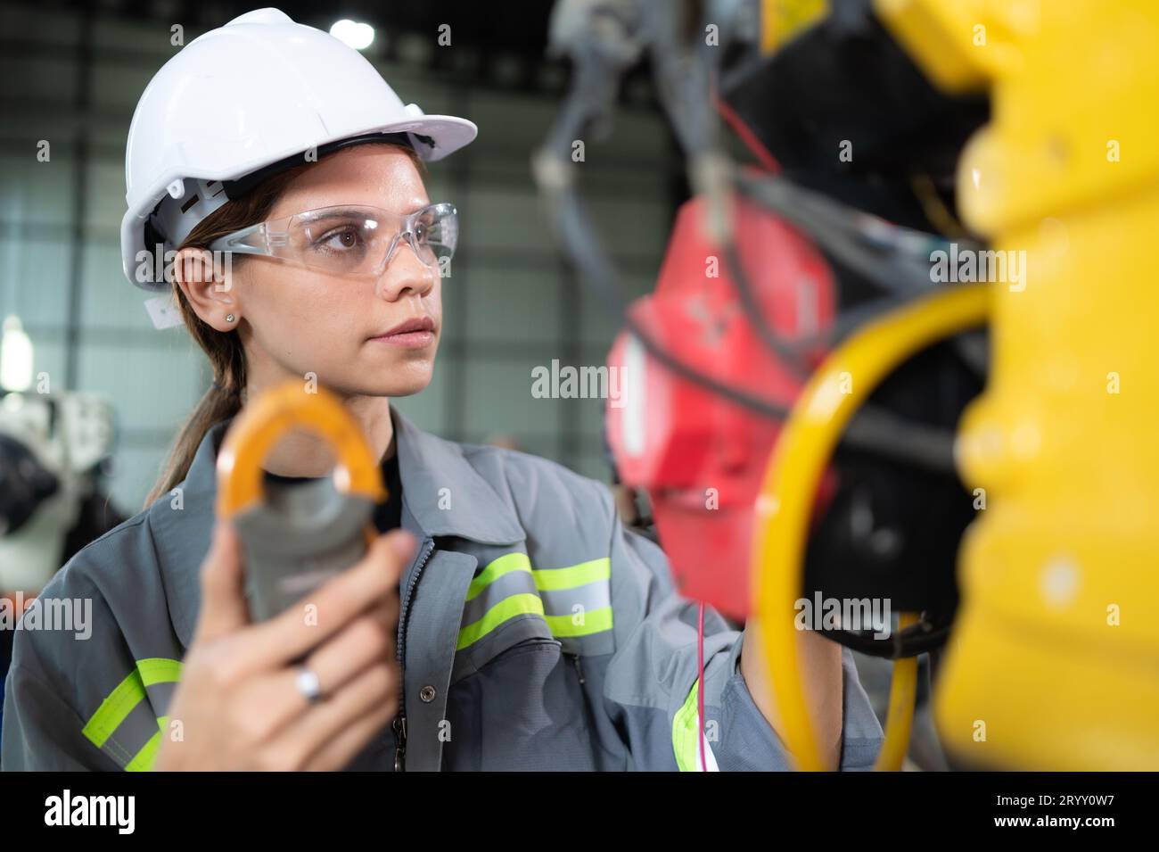 In the robots warehouse, A female engineer inspects the electrical ...