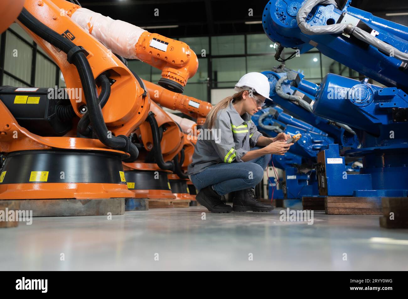 In the robots warehouse, A female engineer inspects the electrical ...