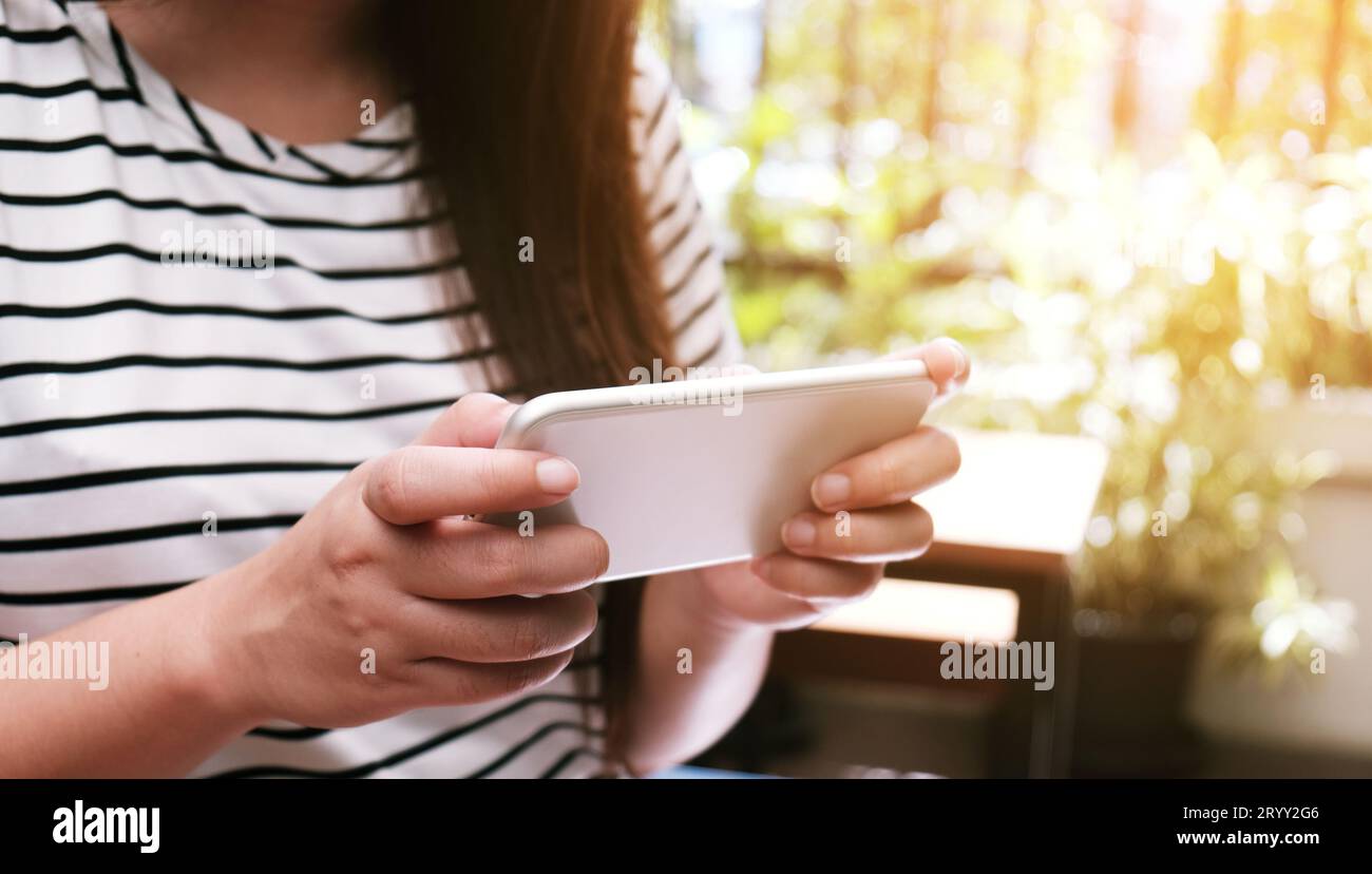Women's hands holding cell telephone watching social media in a smart ...