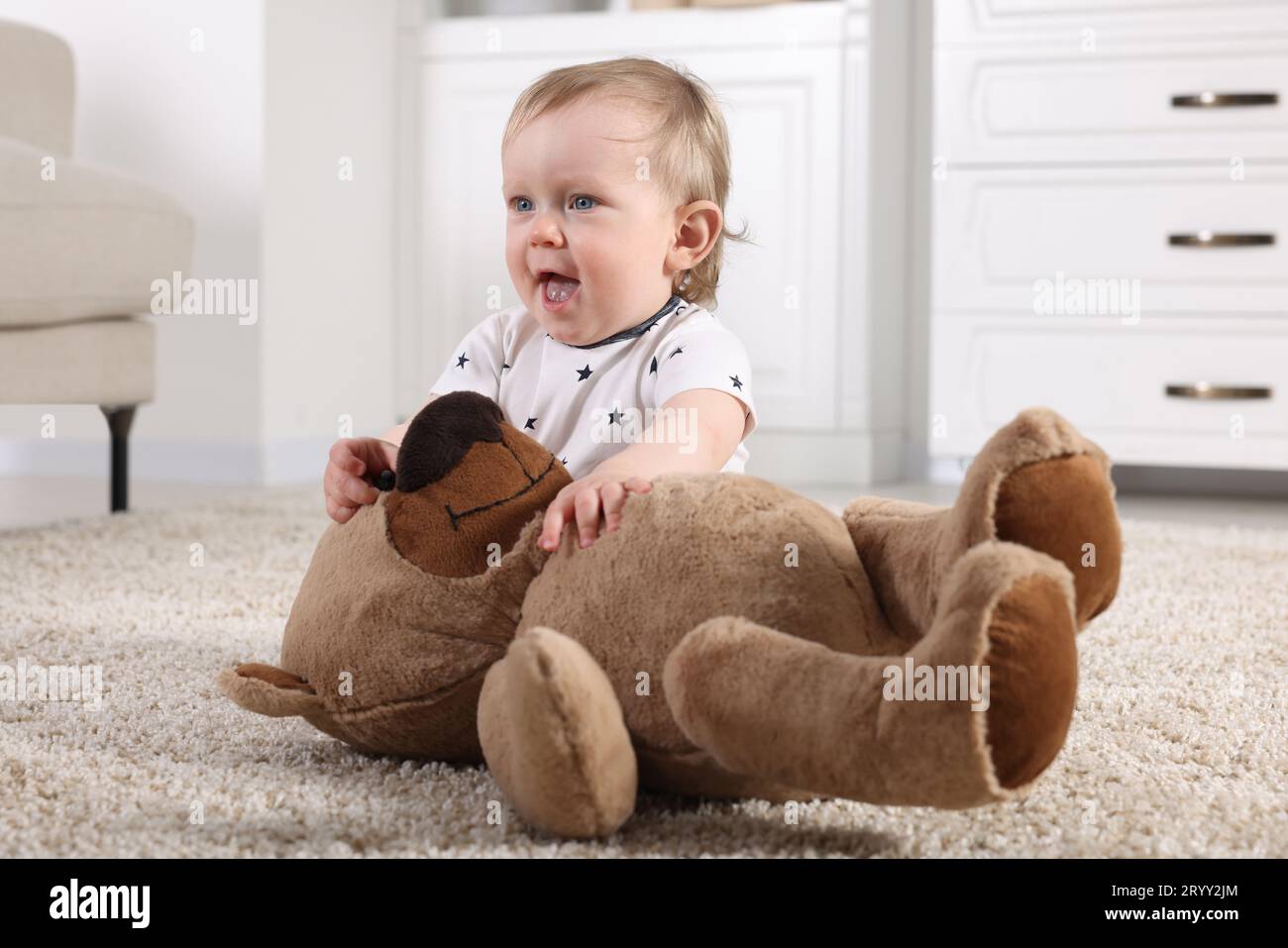 Cute little child with teddy bear on carpet at home Stock Photo - Alamy
