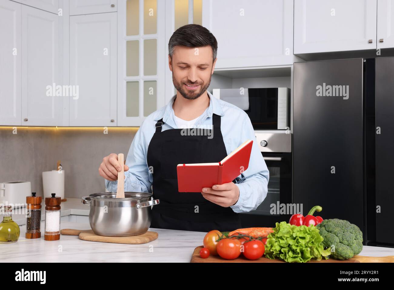 Man in apron writing in kitchen hi-res stock photography and images - Alamy