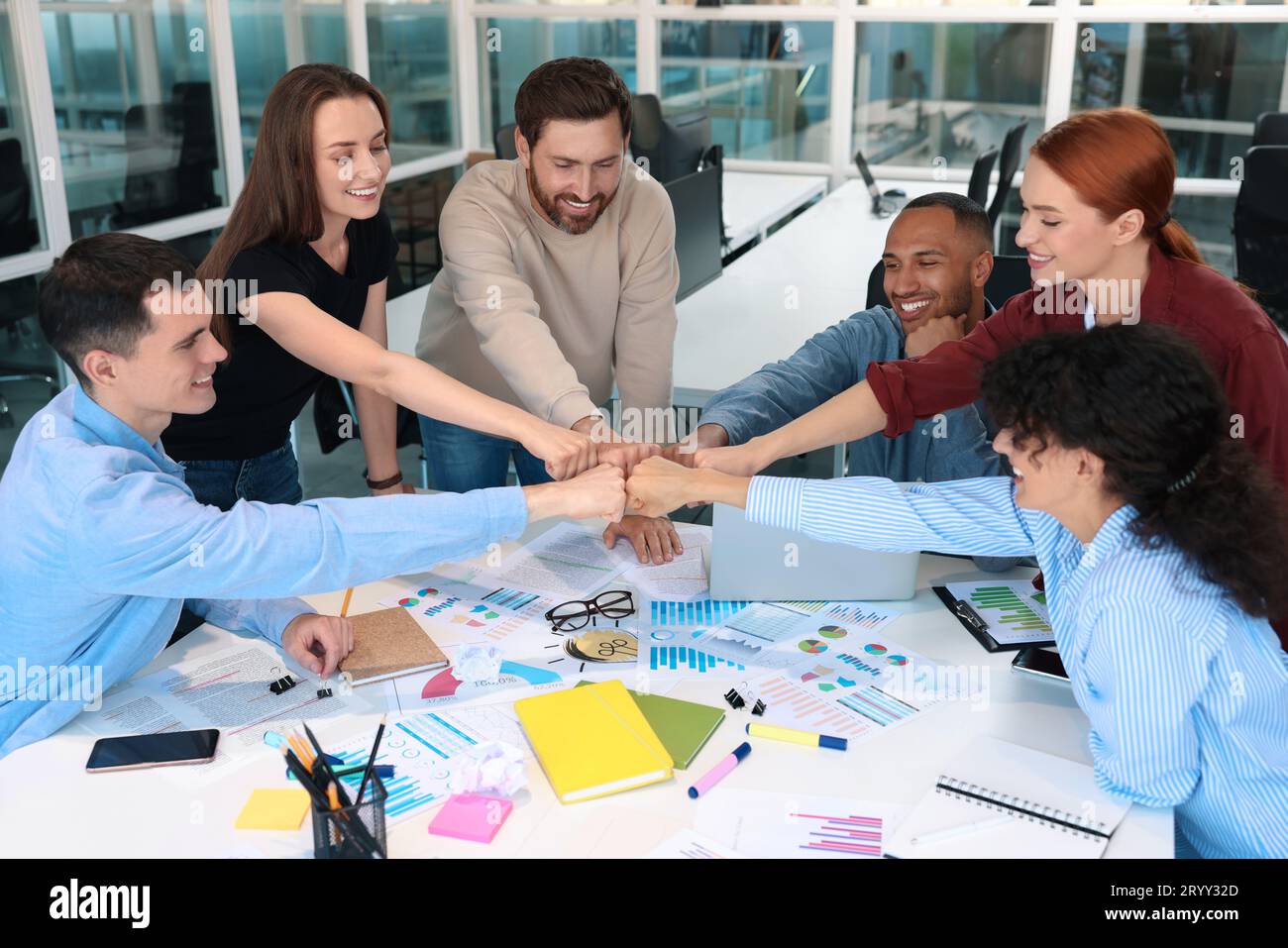 Team of employees joining hands in office. Startup project Stock Photo ...