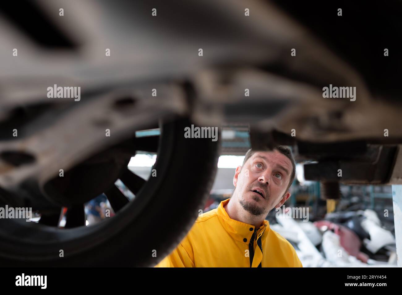 Auto repair mechanic the undercarriage of the car is being inspected ...