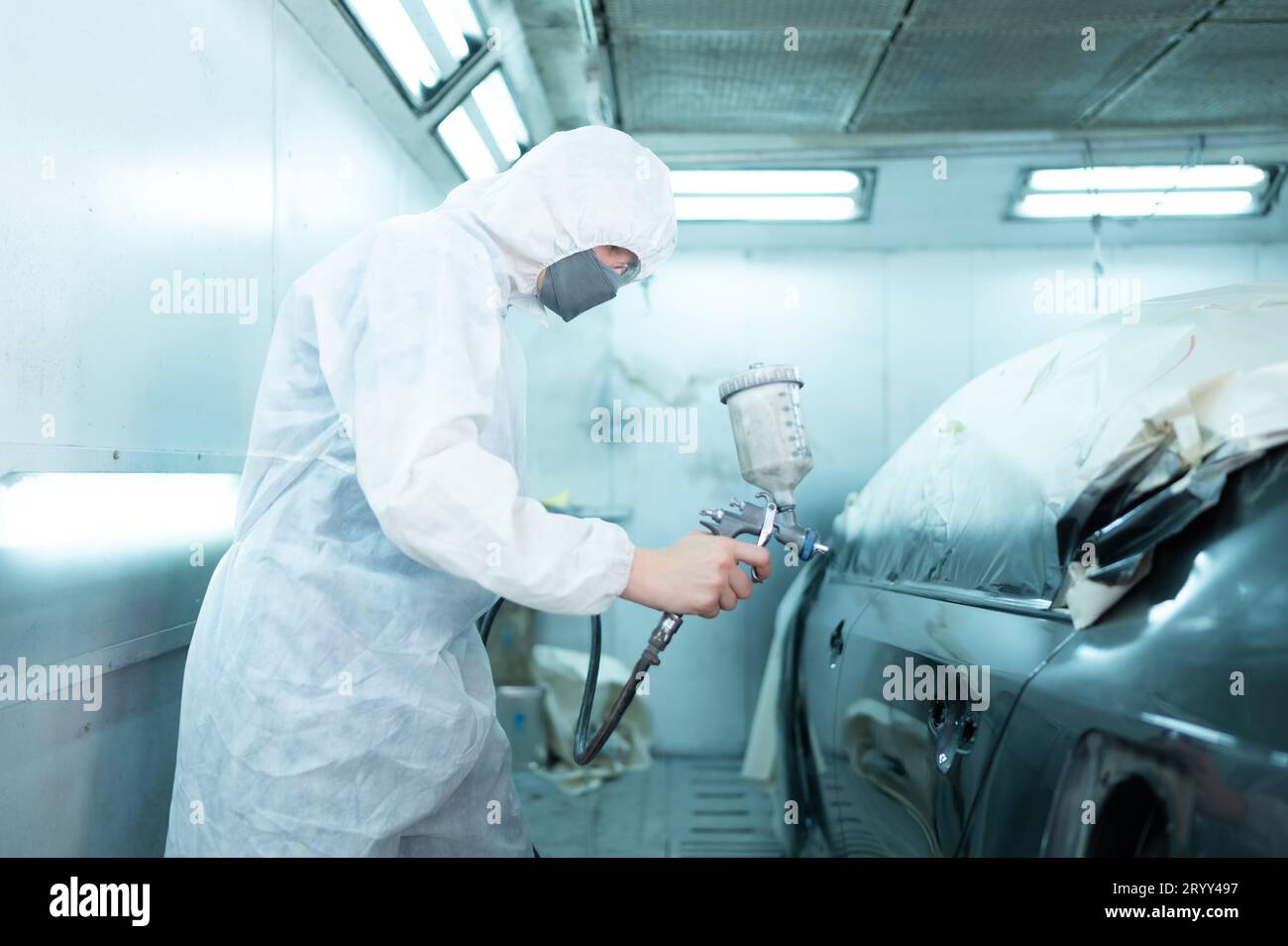 Auto mechanic in car spray room Use a spray nozzle Injected to the side ...