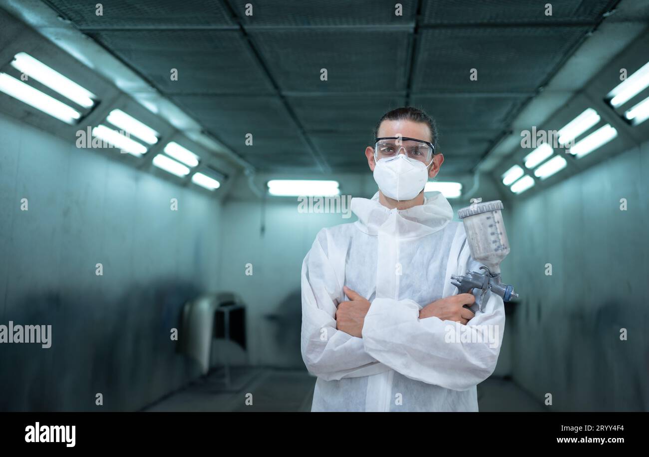 Auto mechanic in car spray room Inspecting the paint sprayed into the ...