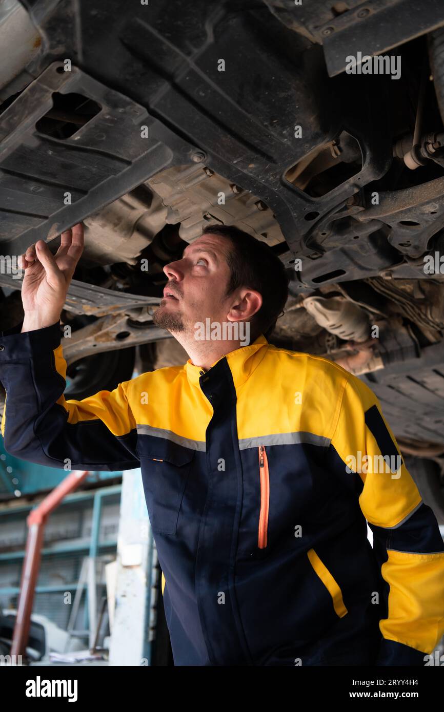 Auto repair mechanic the undercarriage of the car is being inspected ...