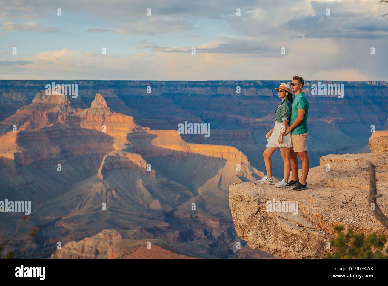 Happy couple on a steep cliff taking in the amazing view over famous ...