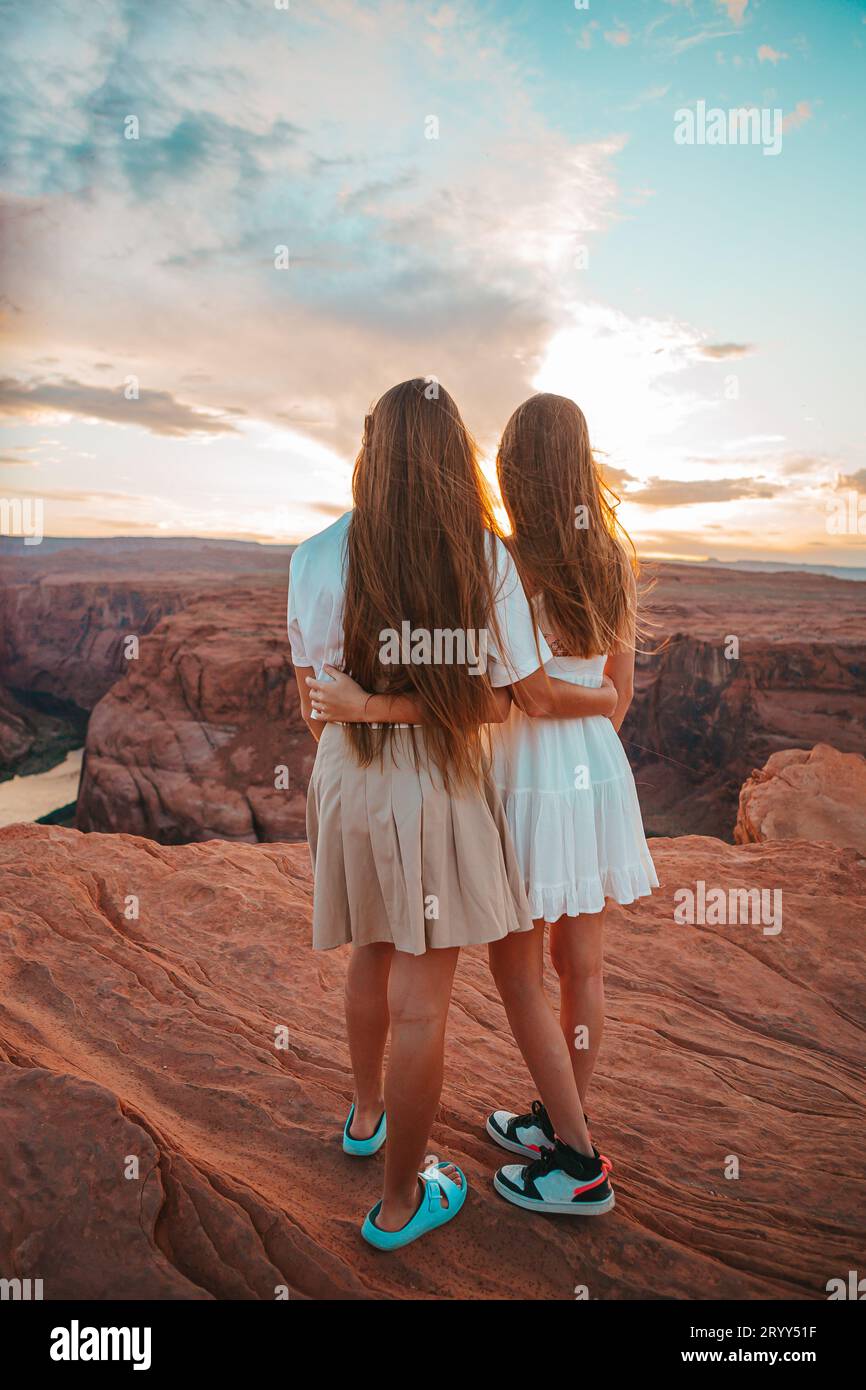 Happy girls on the edge of the cliff at Horseshoe Band Canyon in Paje ...