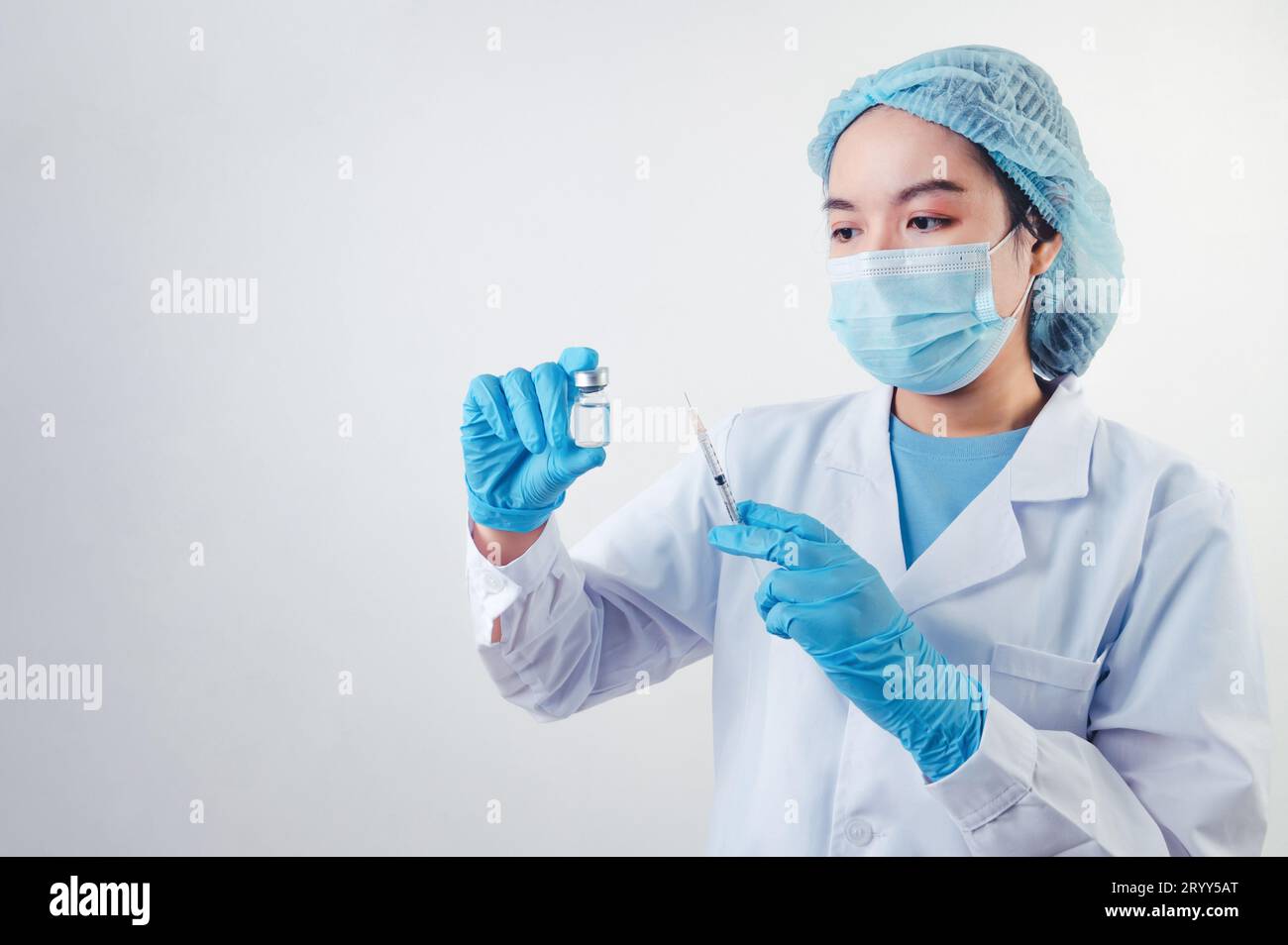 Asian doctor looking and preparing syringe vaccine and vial for ...