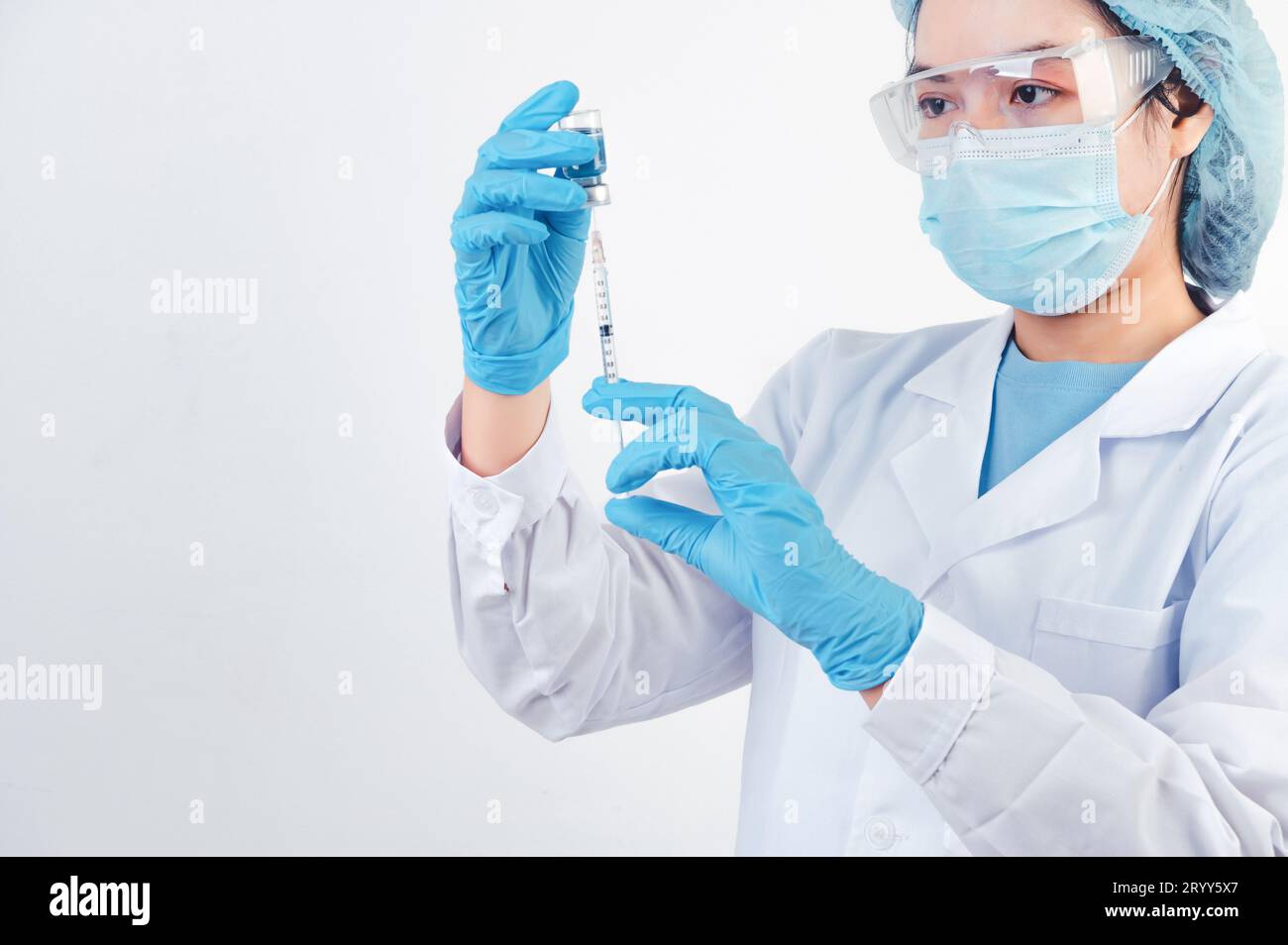 Asian doctor looking and preparing syringe vaccine and vial for ...