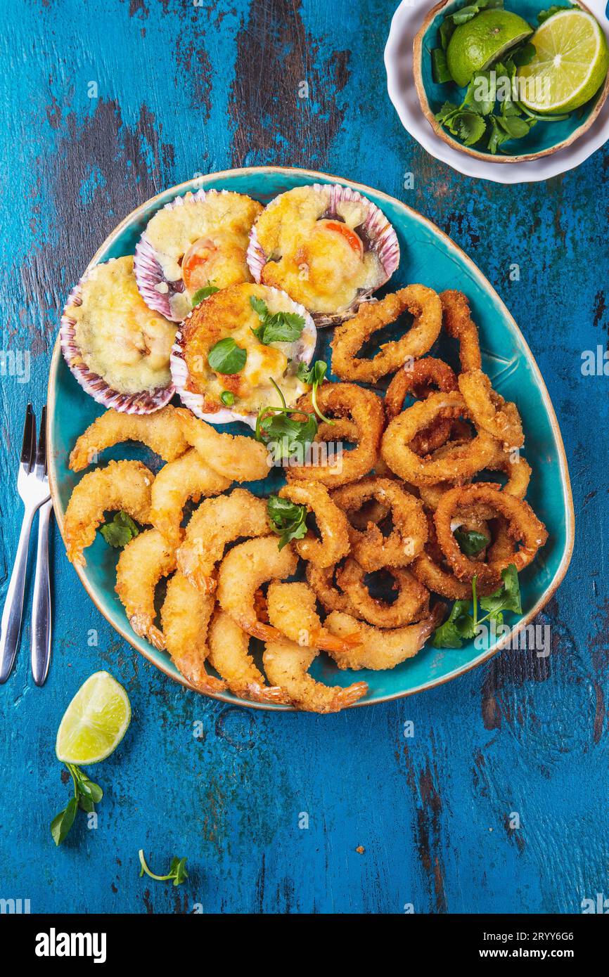 SEAFOOD hot platter baked scallops, fried squid rings and shimps Stock ...