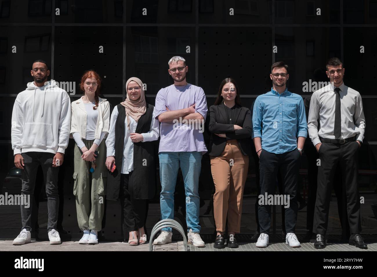 A diverse and confident group of young businessmen poses together ...