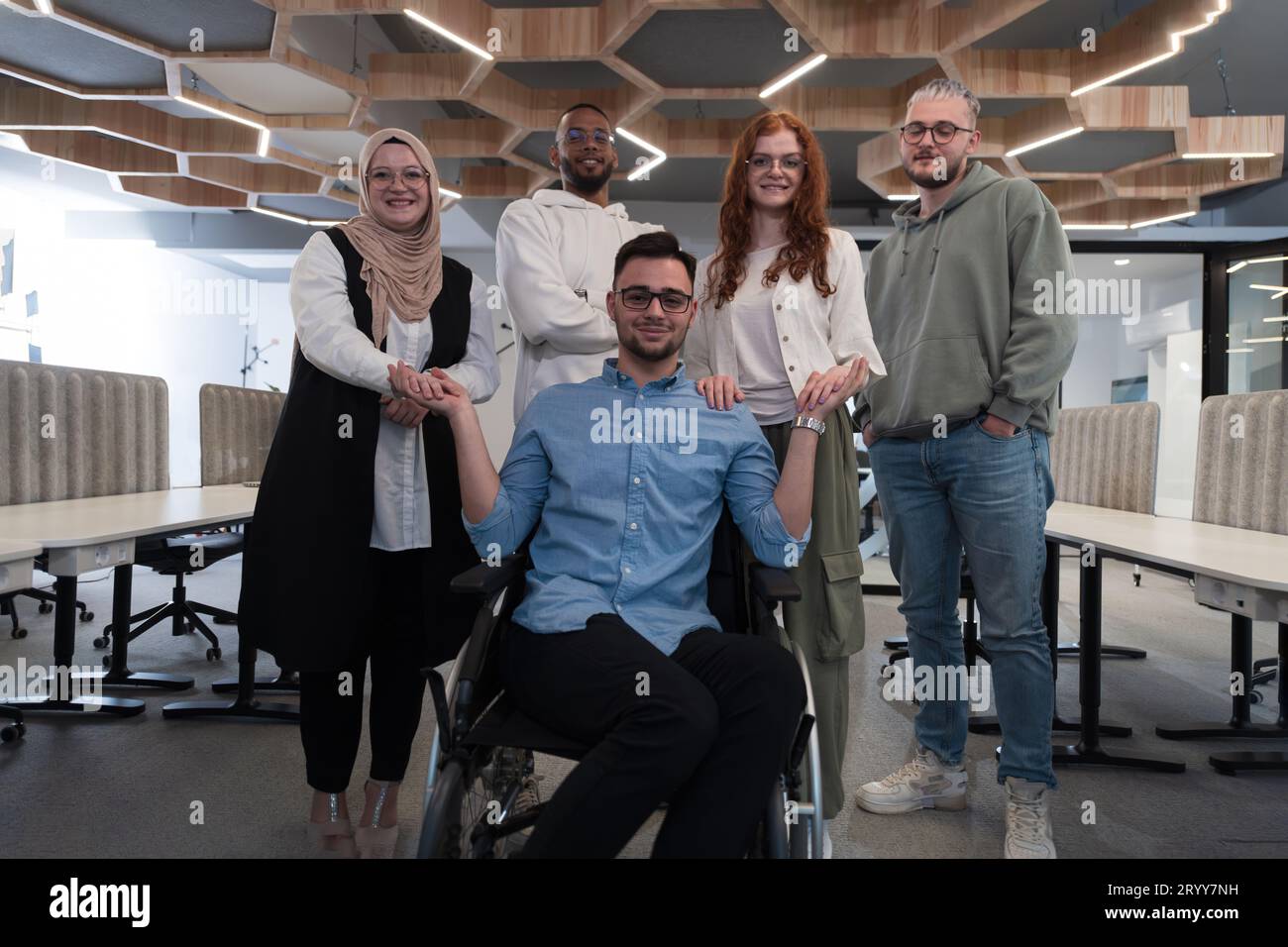 Young businessmen in a modern office extend a handshake to their ...