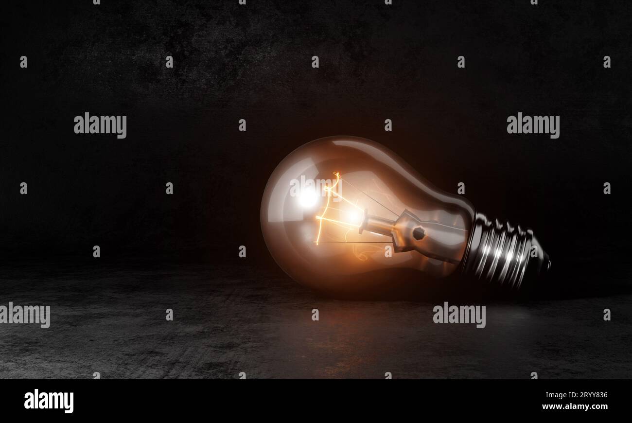 Light bulb with orange warm white light in dark room background and ...