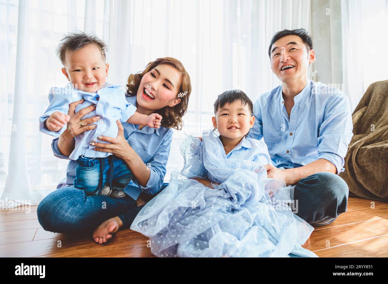 Happy Asian family smile and laugh together in living room at home. Two ...