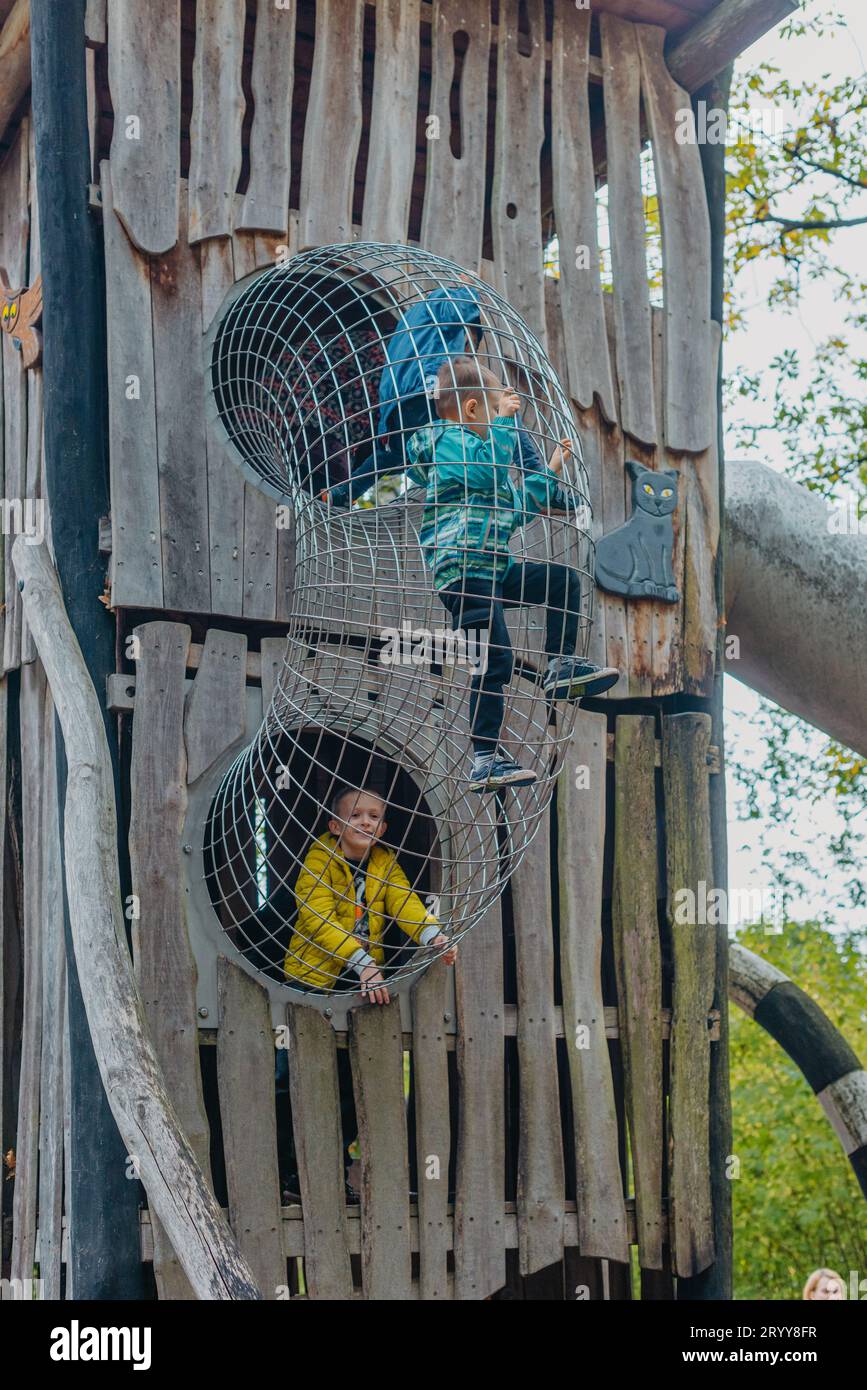 A child climbs up an alpine grid in a park on a playground on a hot ...