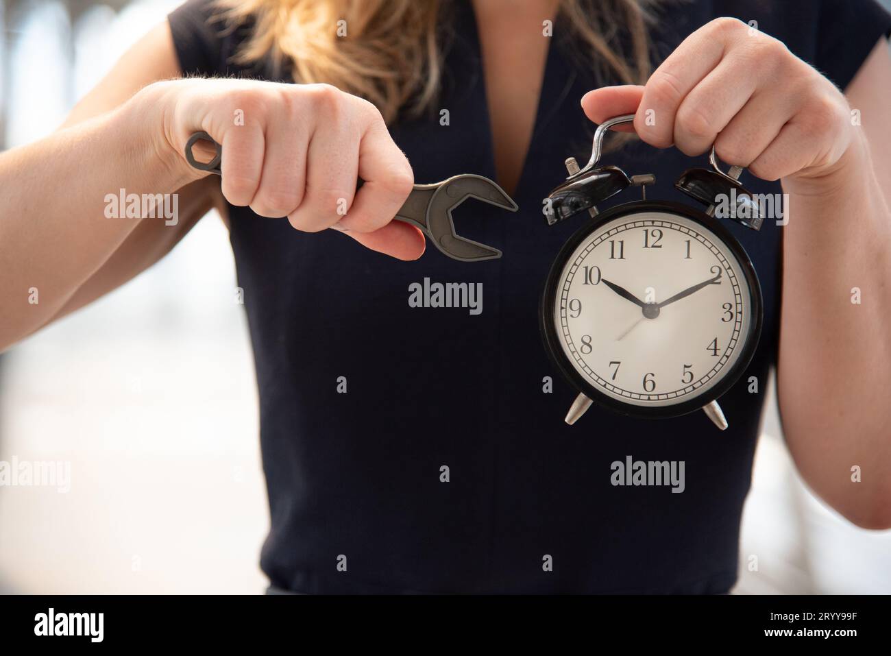 Business woman try to adjust time on alarm clock after shocked with ...