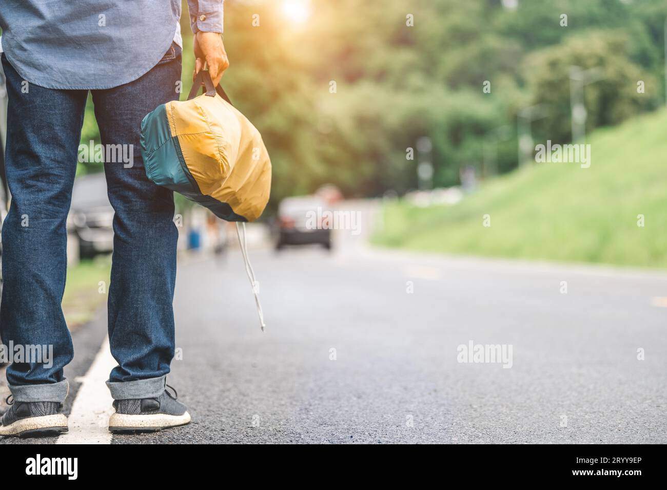 Closeup of tourist legs walking along road with bag during travel in ...