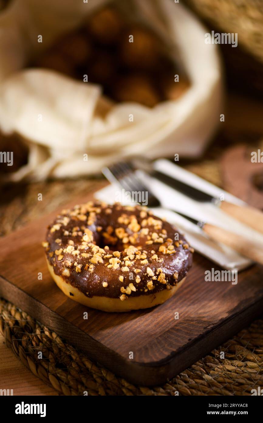 An enticing close-up shot of a donut on a wooden board. White napkin ...