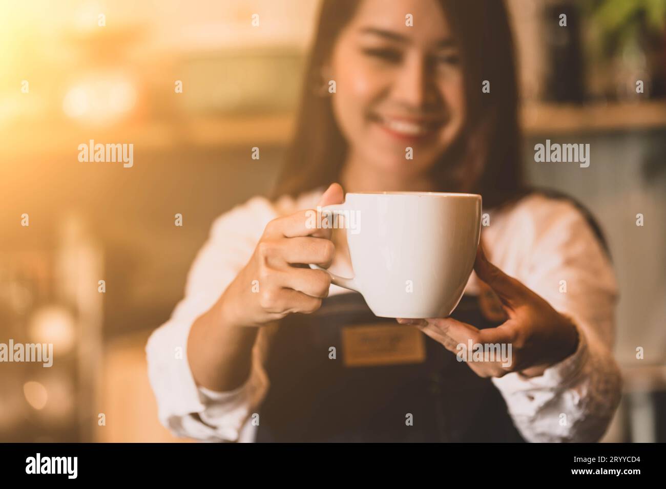Closeup of white coffee cup with beautiful Asian woman barista ...