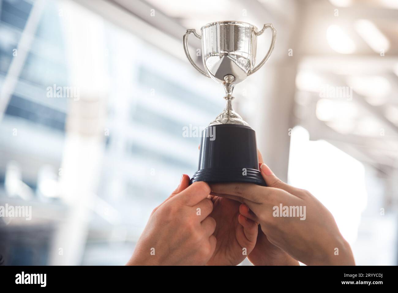 Champion silver trophy for runner up winner with sport player hands in ...