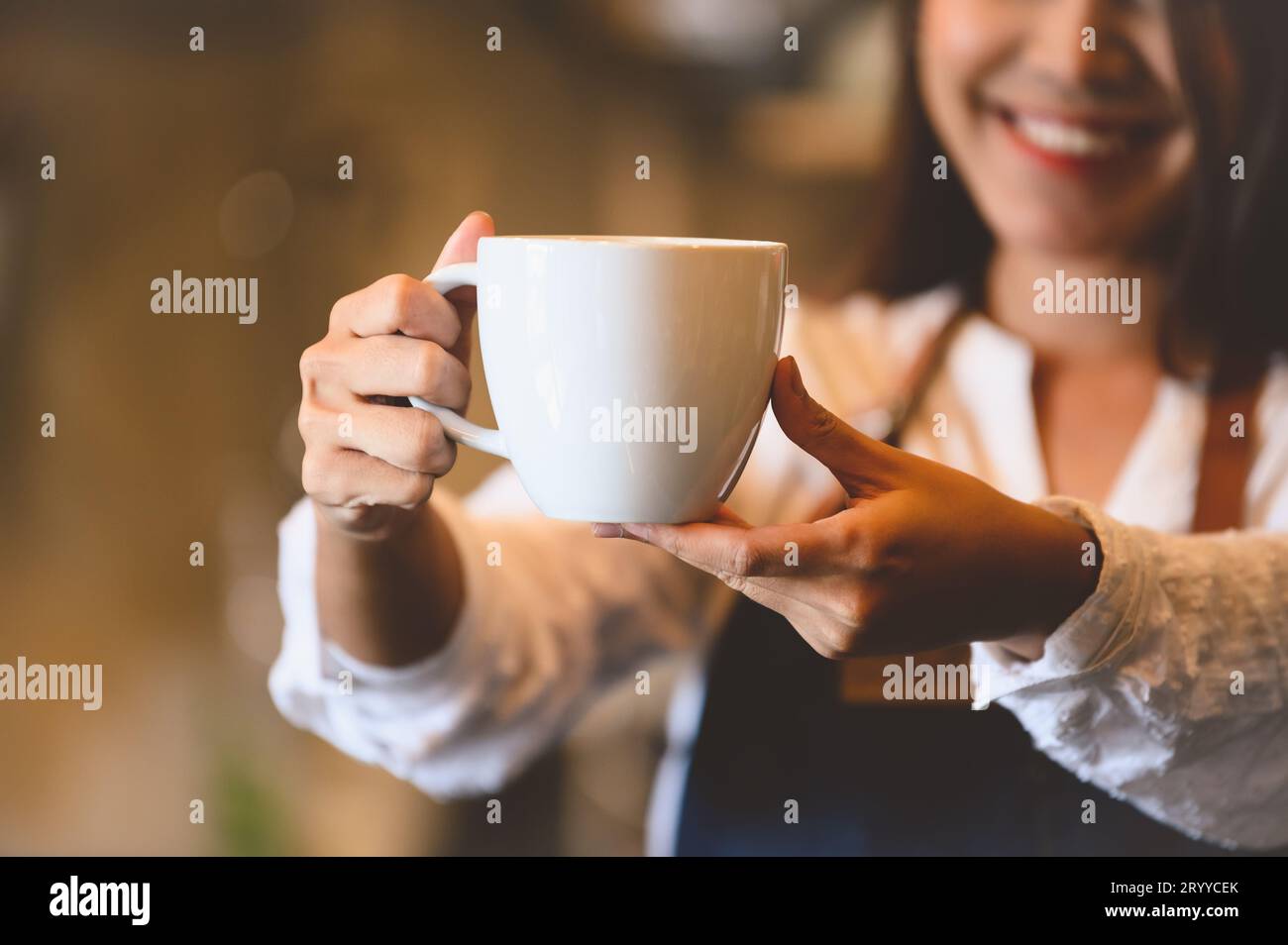 Closeup of white coffee cup with beautiful Asian woman barista ...
