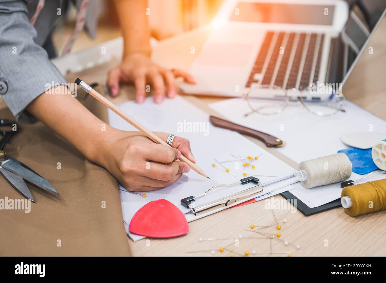 Closeup of attractive female fashion designer hand working in home ...