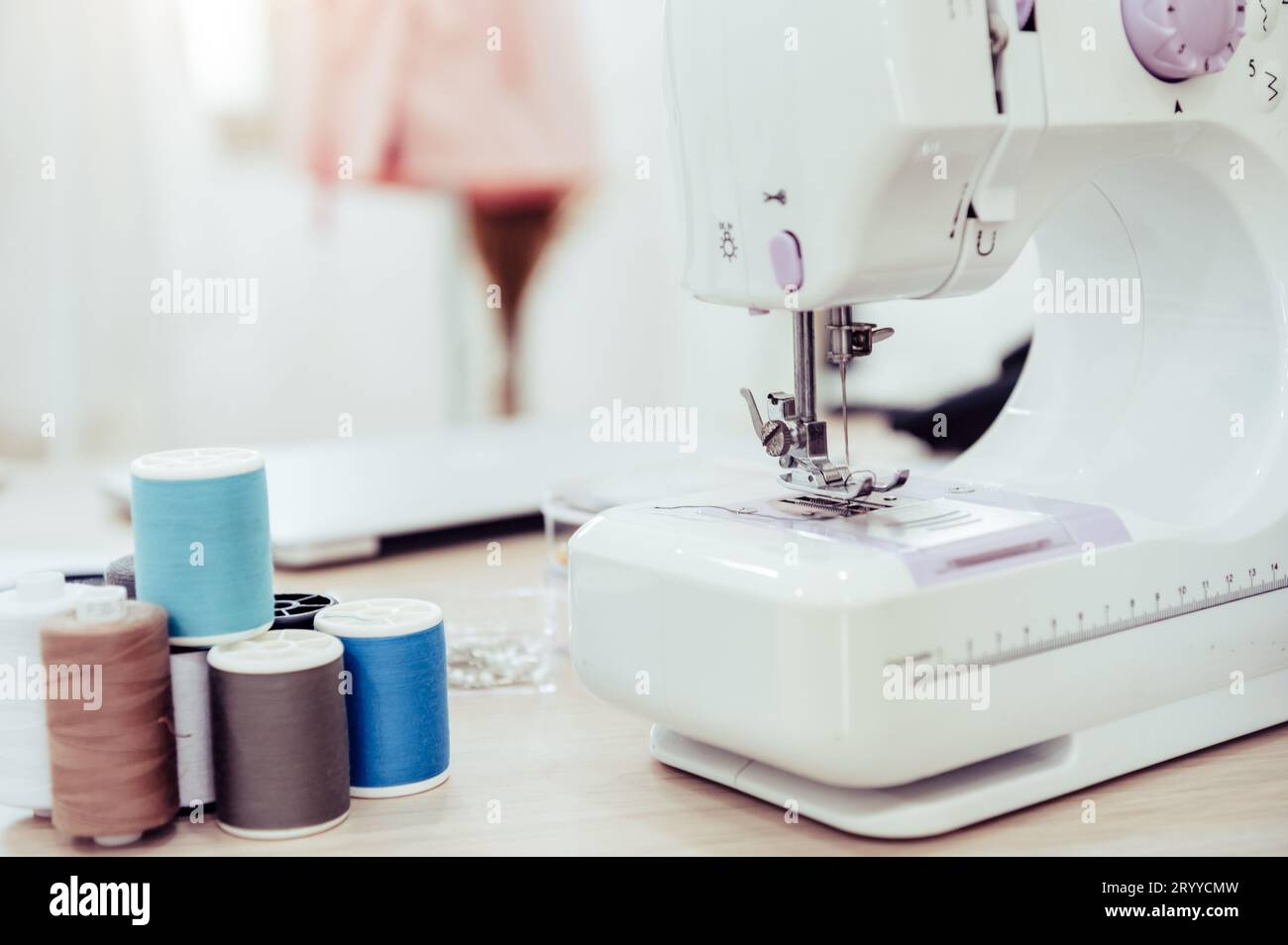 Closeup of sewing machine with fashion designer showroom studio ...