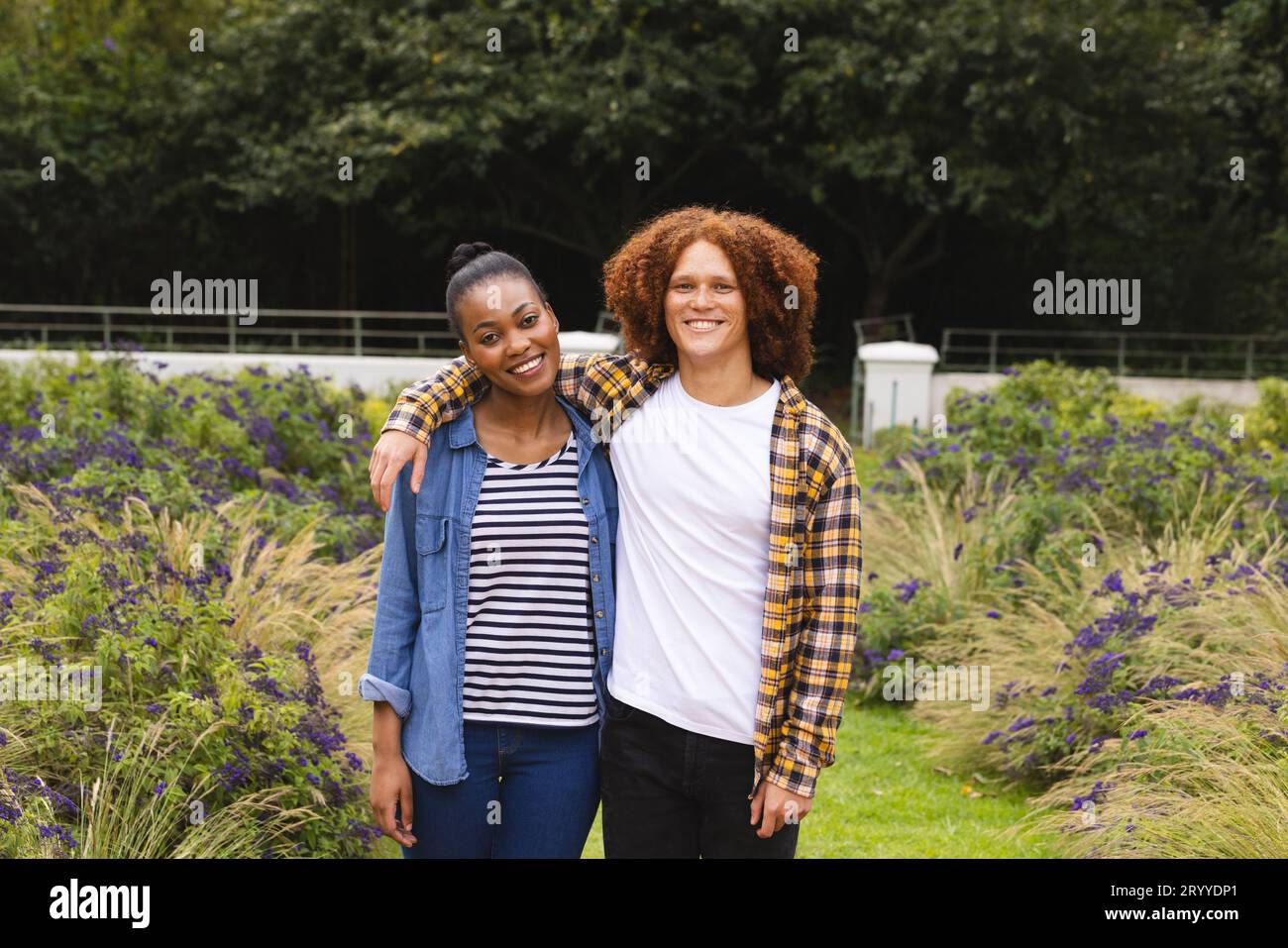 Portrait of happy diverse couple embracing in garden Stock Photo - Alamy
