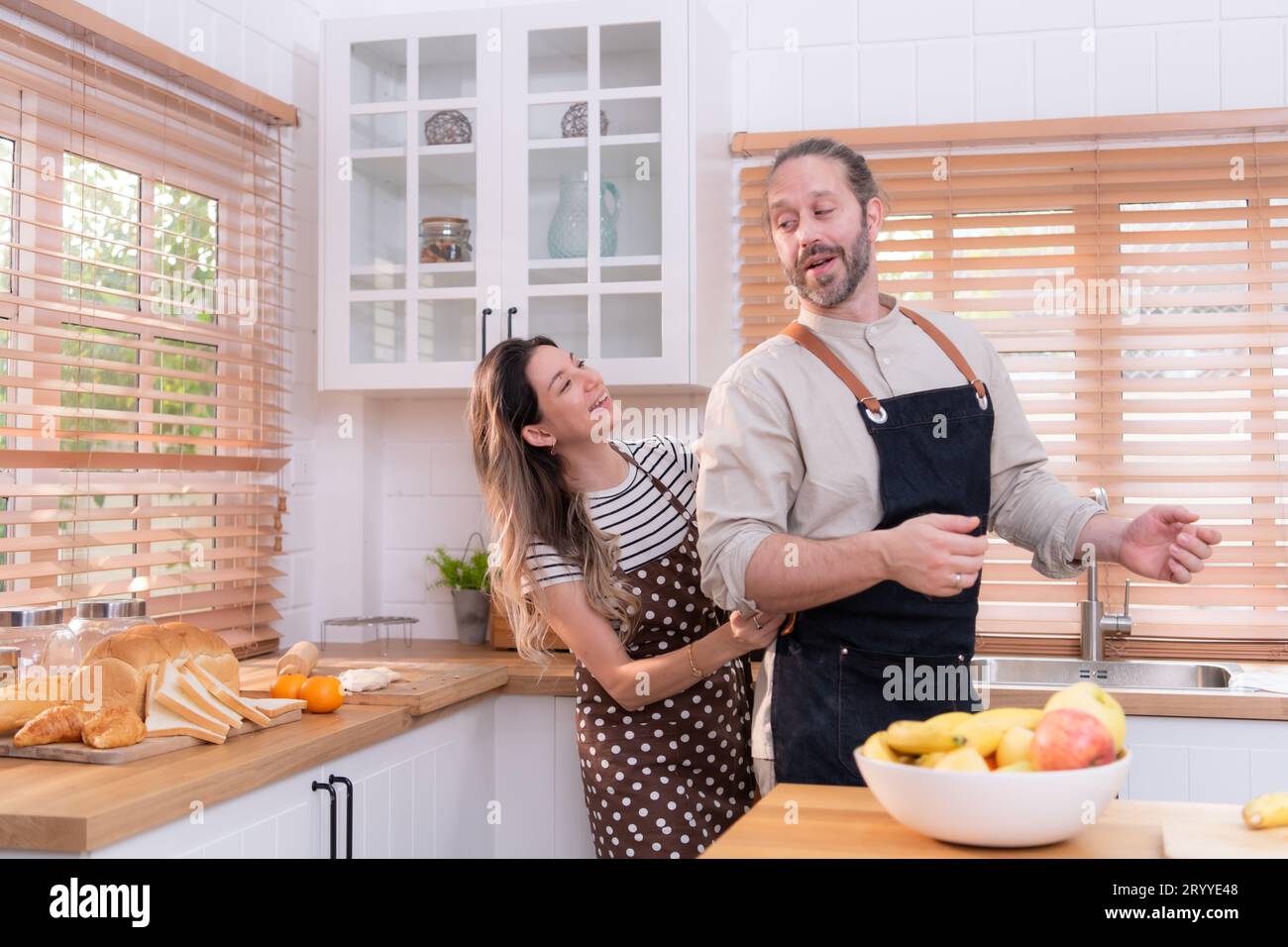 Father and mother in the house's kitchen have a good time making dinner ...