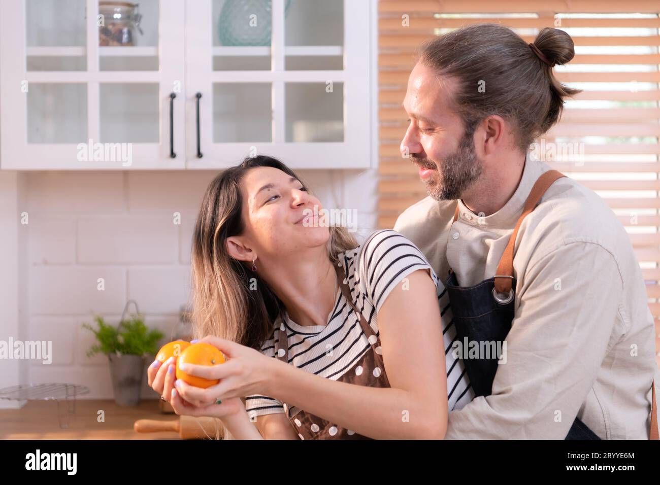 Father and mother in the house's kitchen have a good time making dinner ...