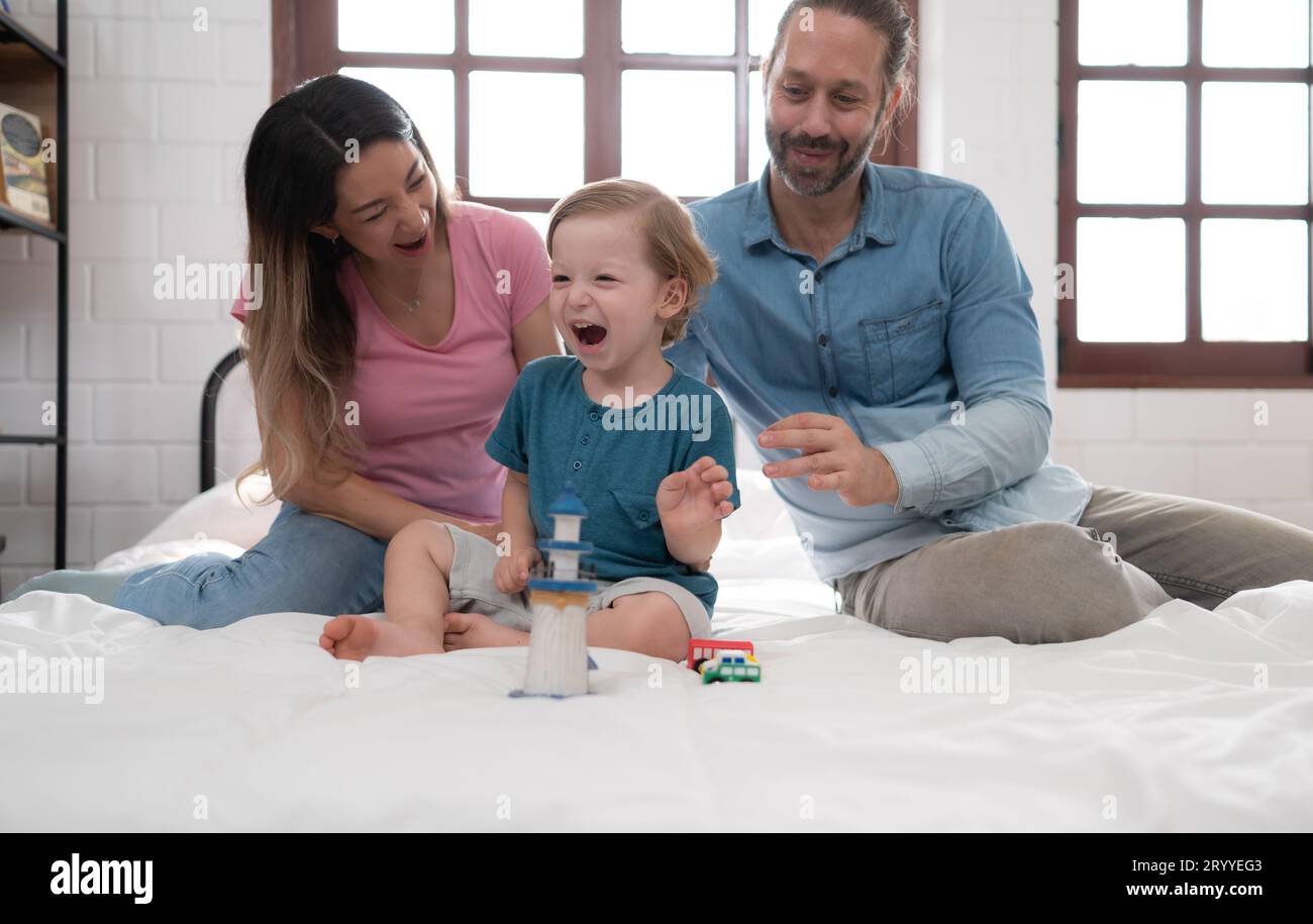 Father and mother with little boy have fun playing with your new toys ...