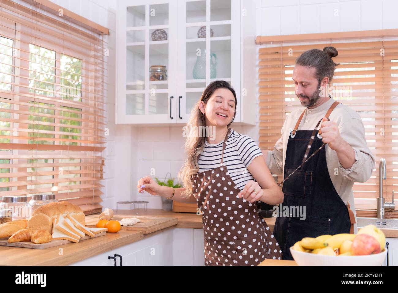 Father and mother in the house's kitchen have a good time making dinner ...
