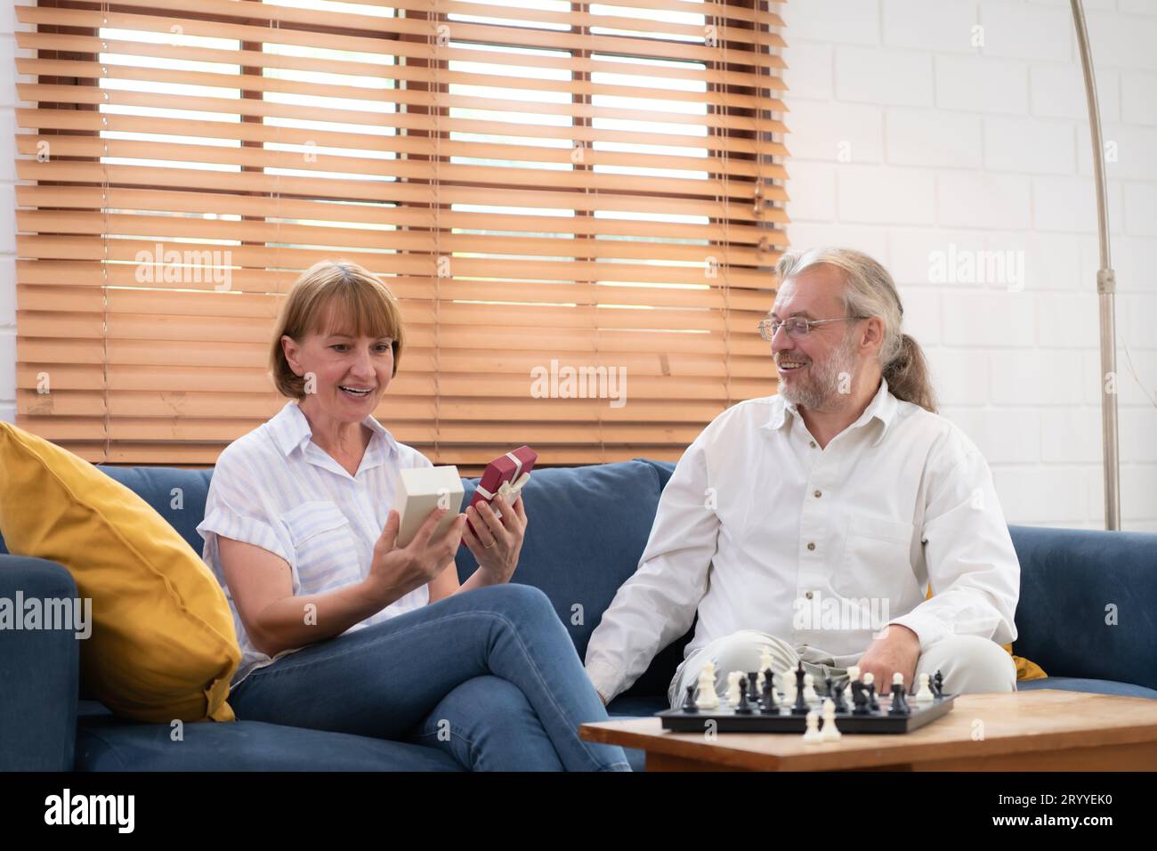 Old couple Sit and relax in the living room of the house. Along with ...