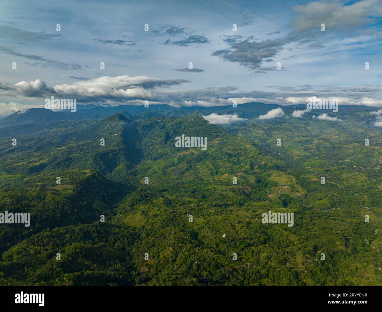 Tropical mountain range and mountain slopes with rainforest. Blue sky ...