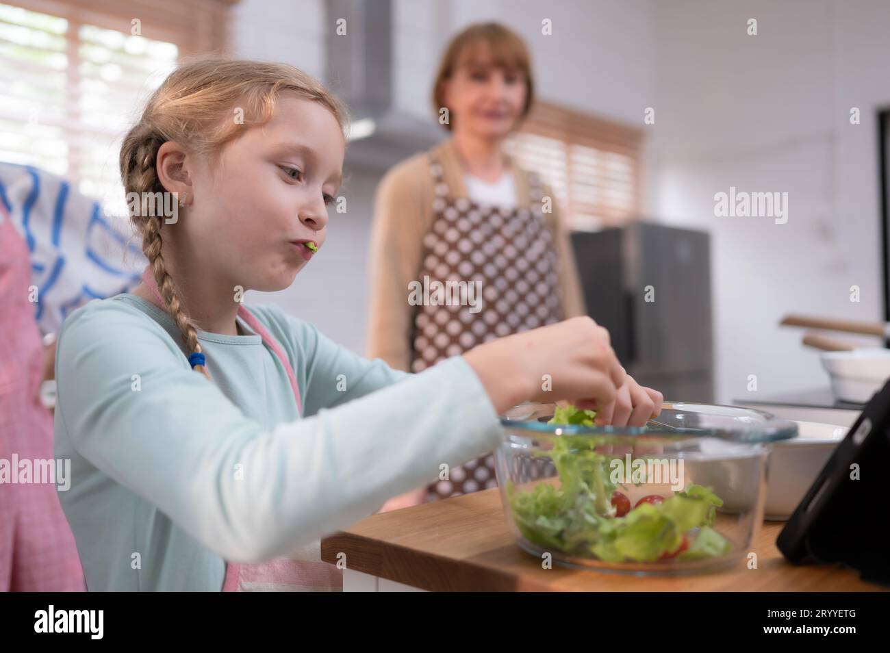 Granddaughter of grandparents in a kitchen with plenty of natural light ...
