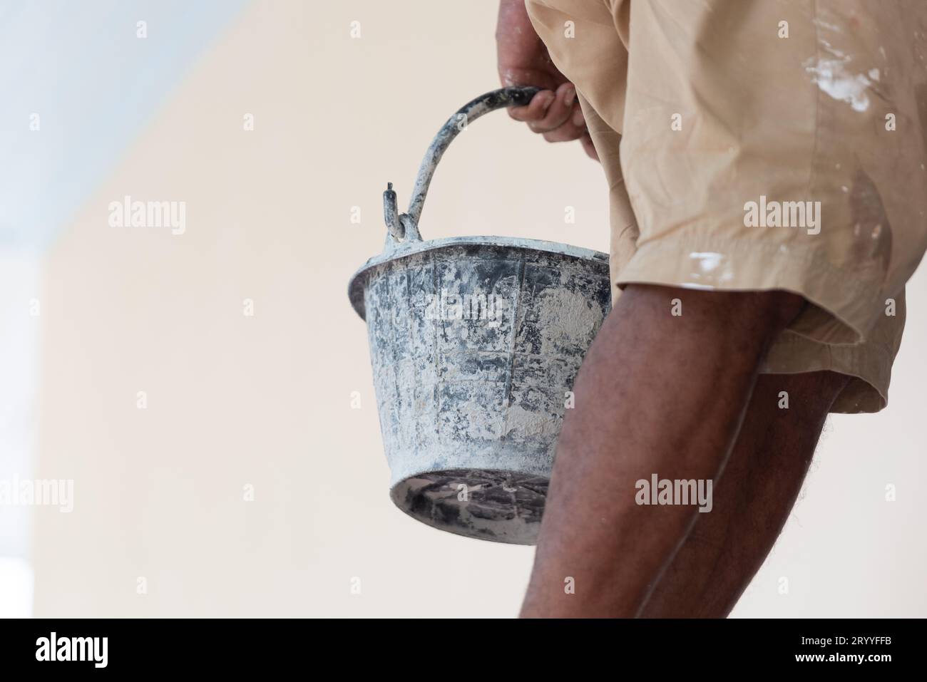 Close up of black paint bucket and painter legs. Architecture and Civil ...
