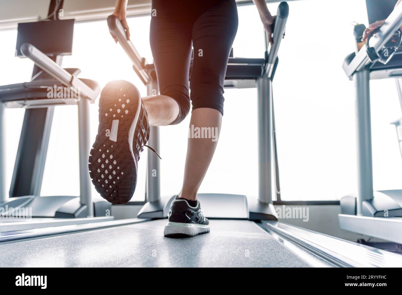Lower body at legs part of Fitness girl running on running machine or ...