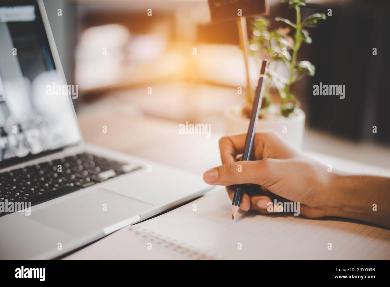 People hand using pencil to draw and noting on notepad. Laptop computer ...