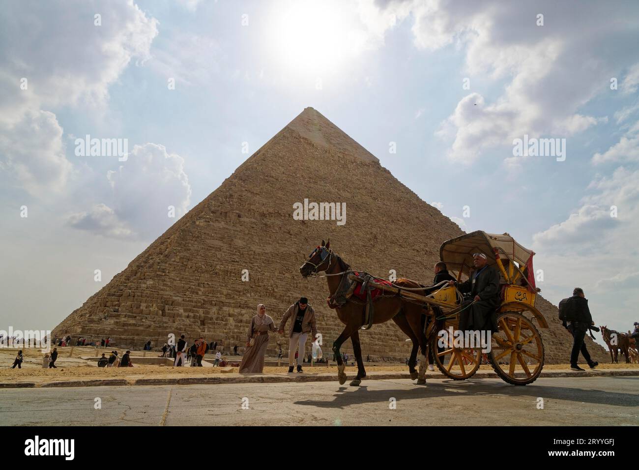 Two-wheeled horse-drawn carriage passes in front of a pyramid, horse ...