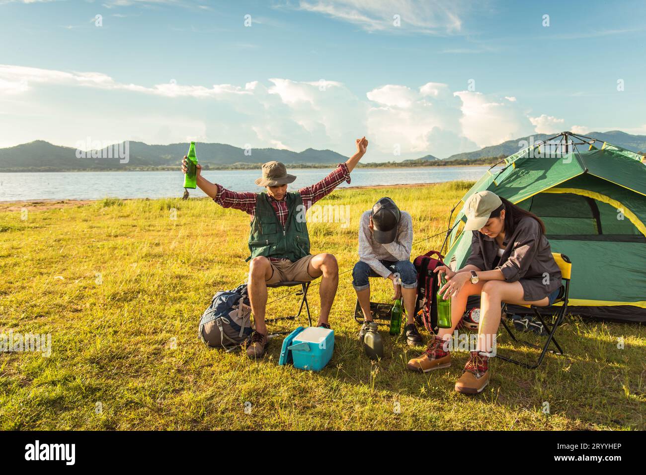 Drunken tourists doing party while camping and picnic in meadow field ...