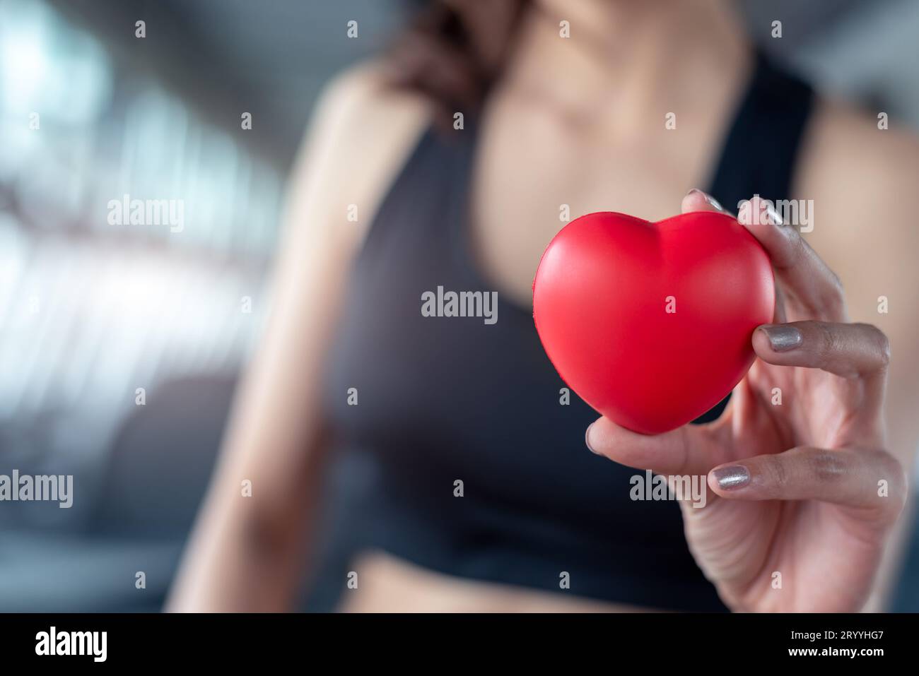 Close up of red massage ball like heart shape in fitness woman hand at ...